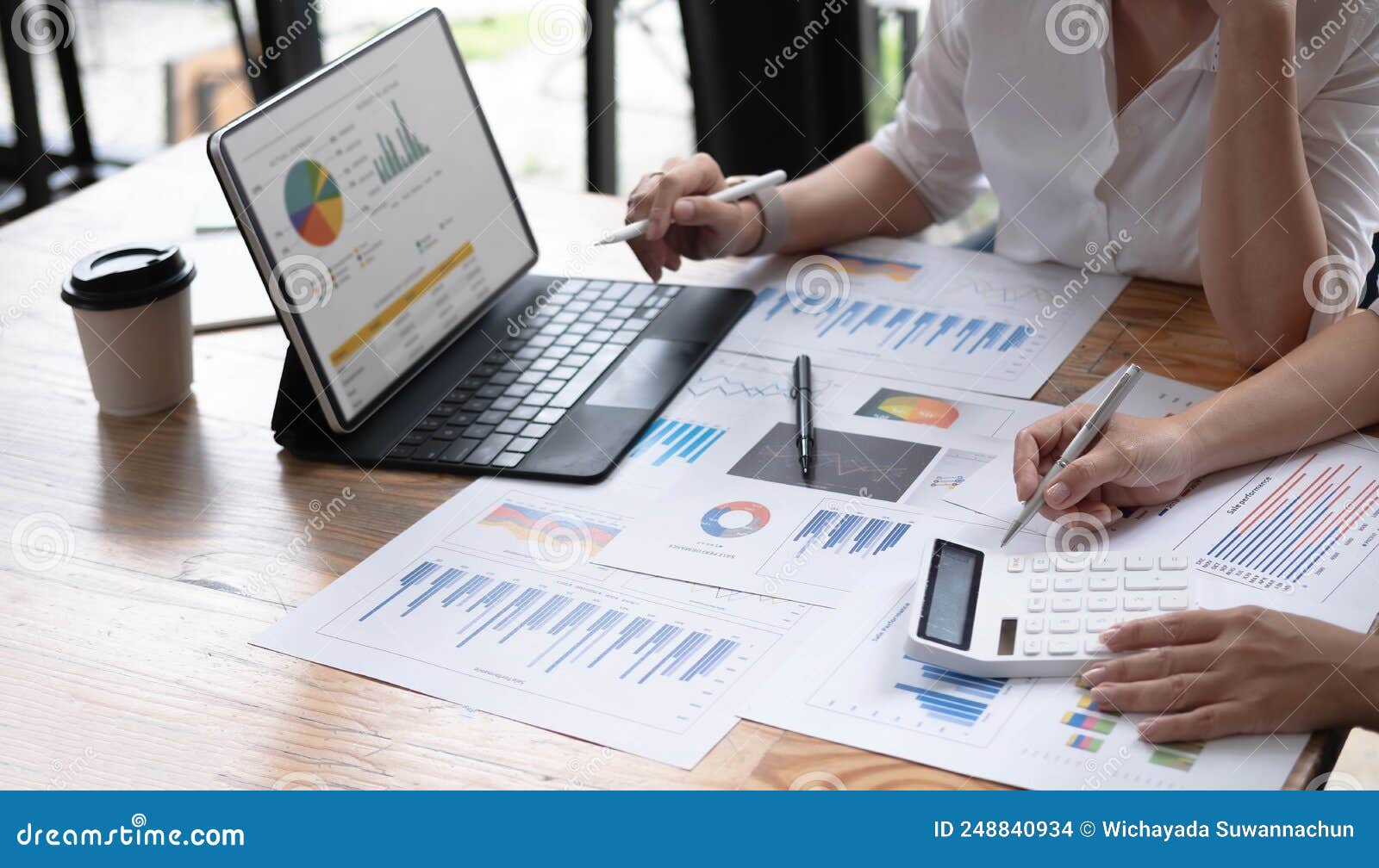 Two Women Analyzing Documents while Sitting on a Table in Office. Woman ...