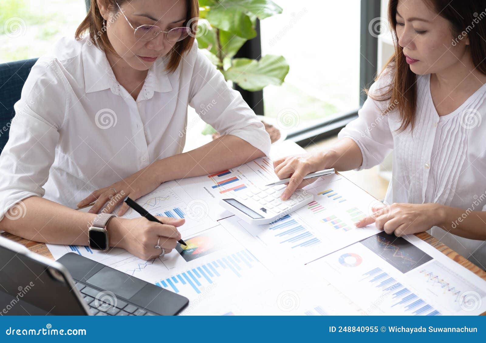 Two Women Analyzing Documents while Sitting on a Table in Office. Woman ...
