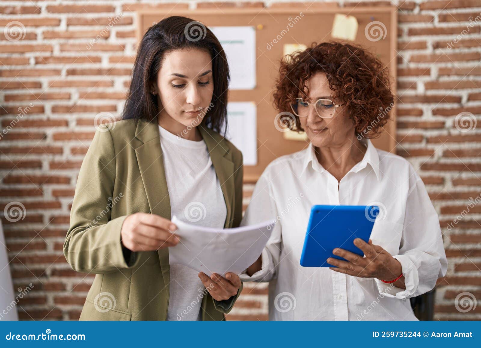 Two Women Business Workers Reading Document Using Touchpad at Office ...