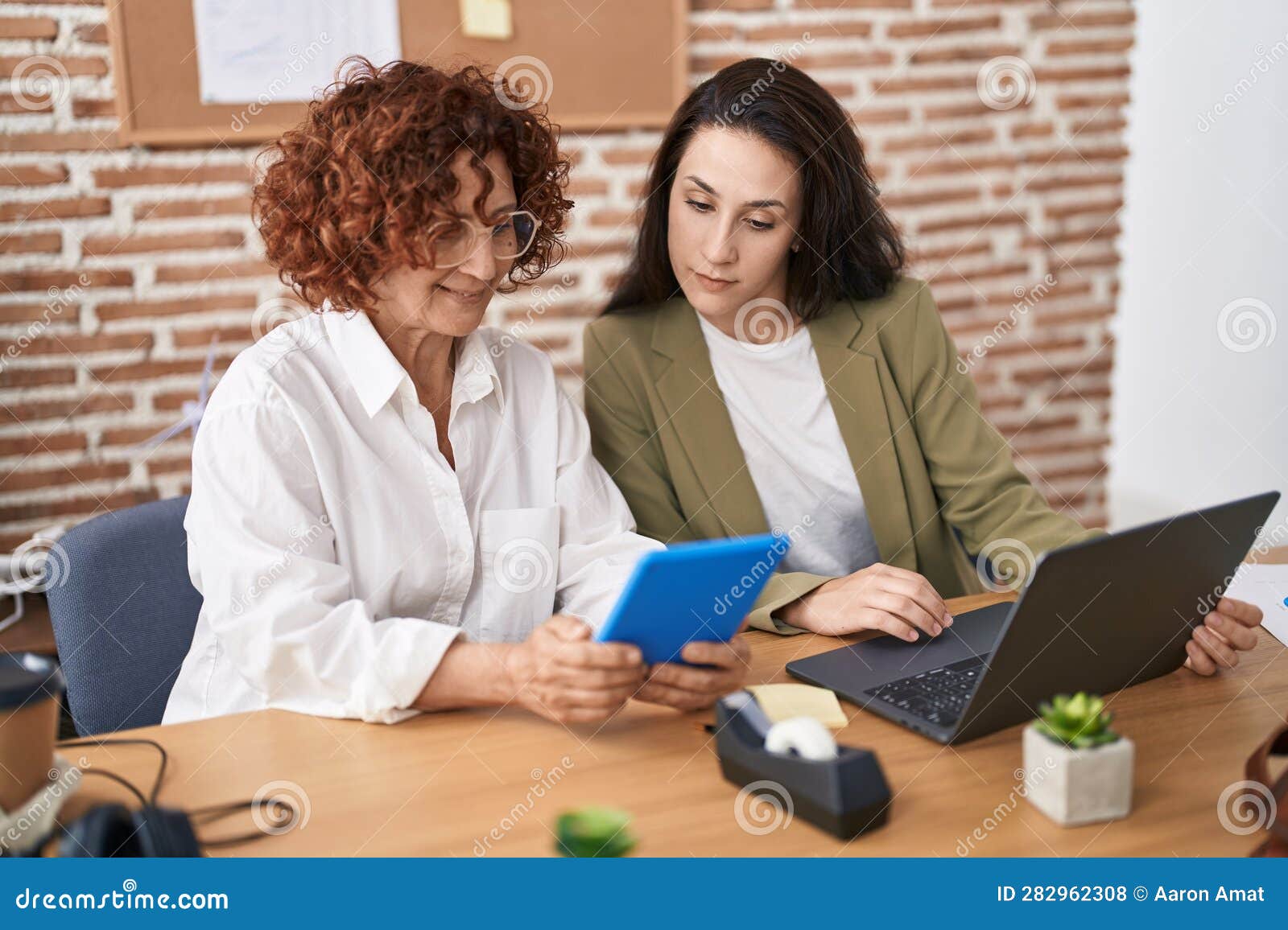 Two Women Business Workers Using Laptop and Touchpad Working at Office ...