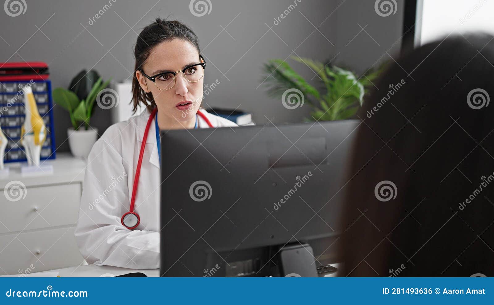 Two Women Doctor and Patient Using Computer Having Consultation at ...