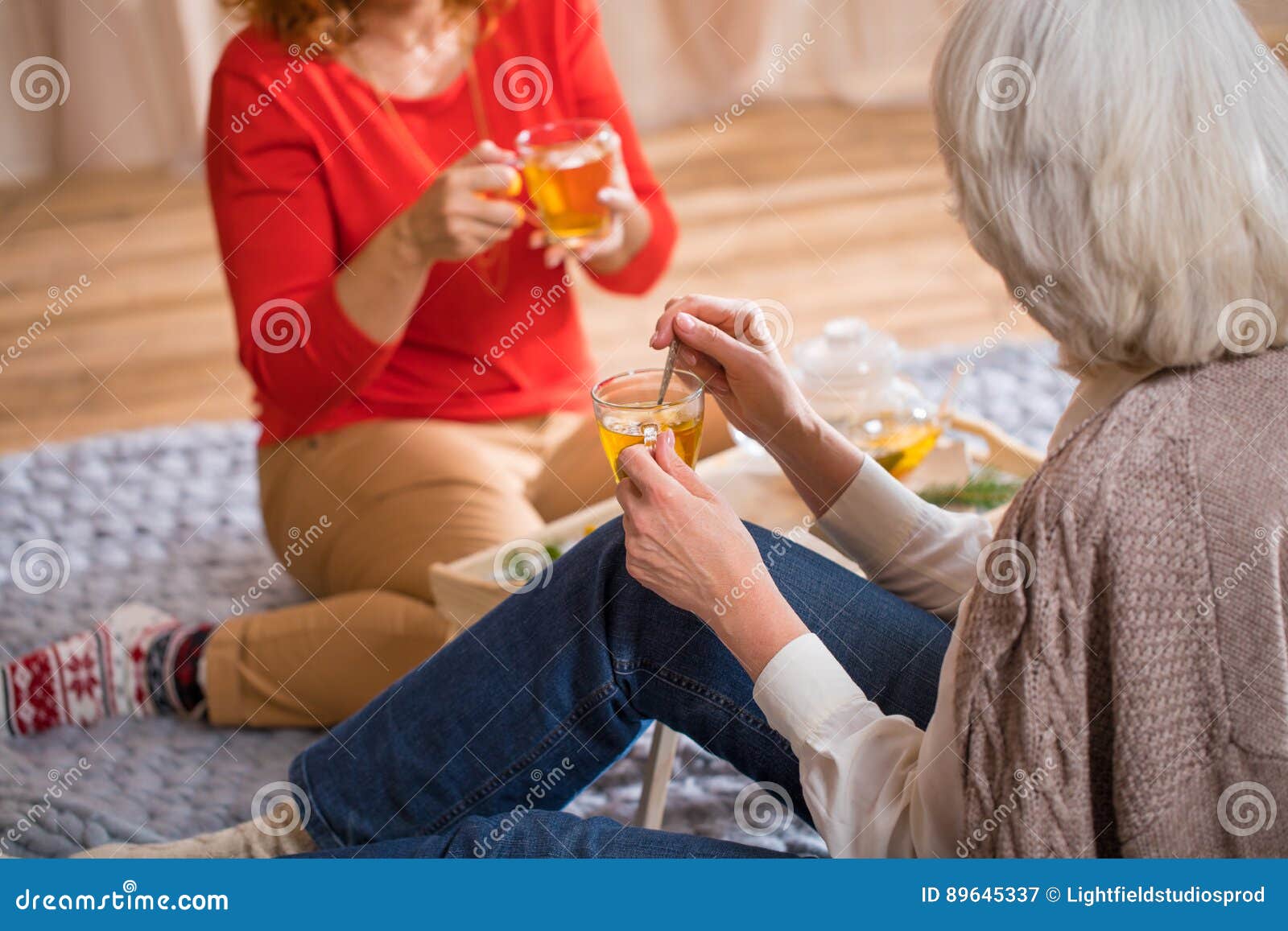 Two women drinking tea stock image. Image of generations - 89645337