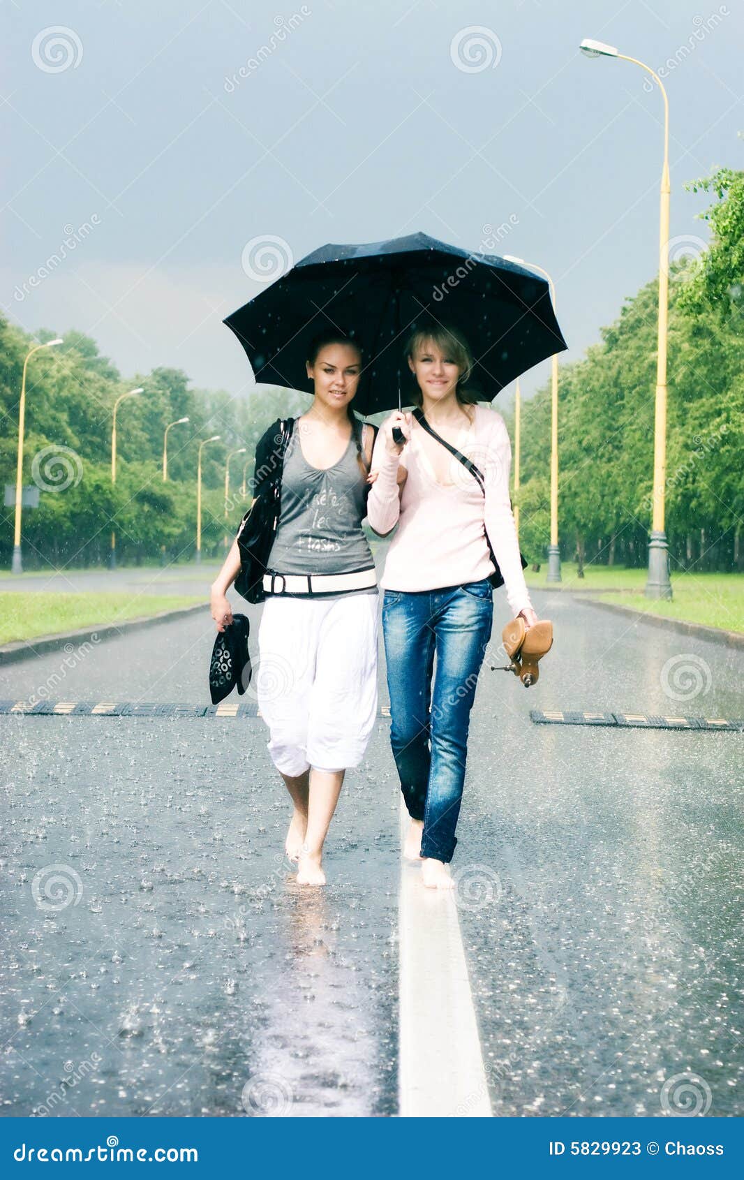Two women in a heavy rain stock image. Image of outdoors - 5829923