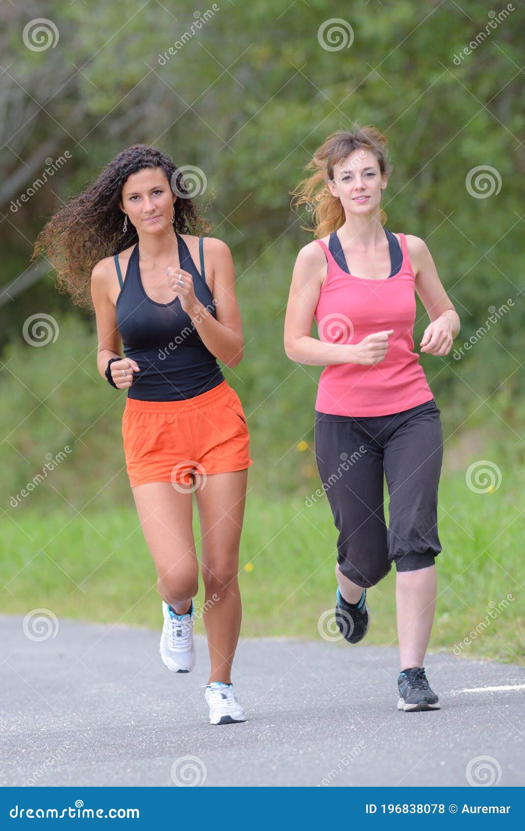 Two women jogging outdoors stock photo. Image of runner - 196838078