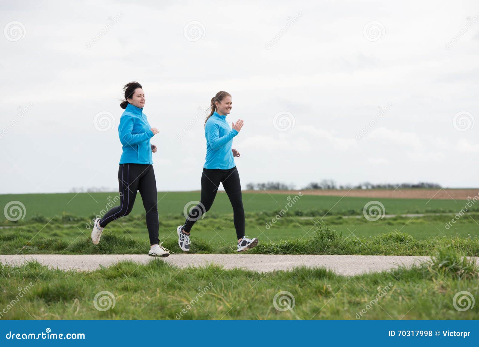 Two women jogging outdoors stock photo. Image of outdoor - 70317998
