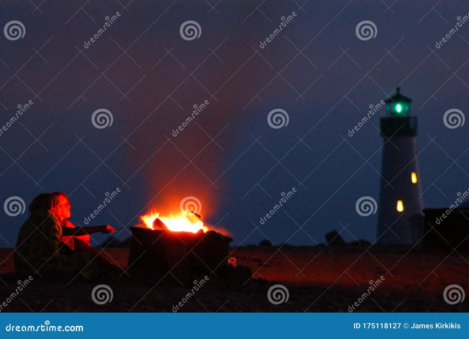Two Women Keep a Fire Going within Sight of a Lighthouse Editorial ...