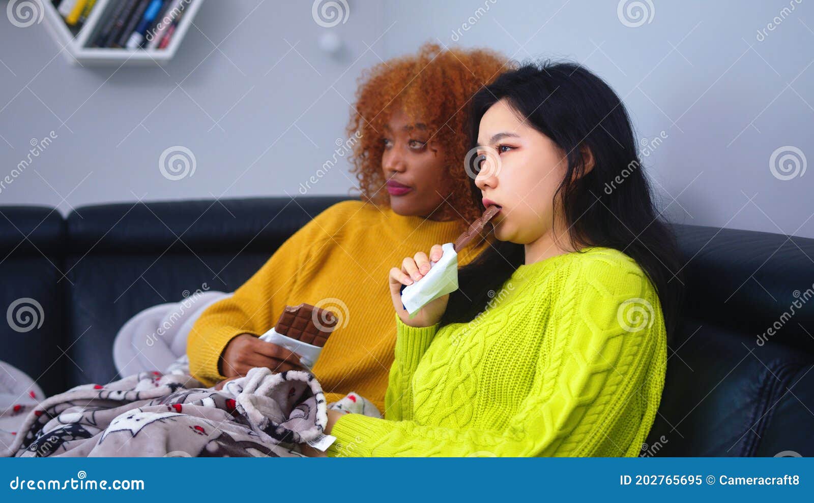 Two Women Lesbian Couple Watching Television And Eating Chocolates