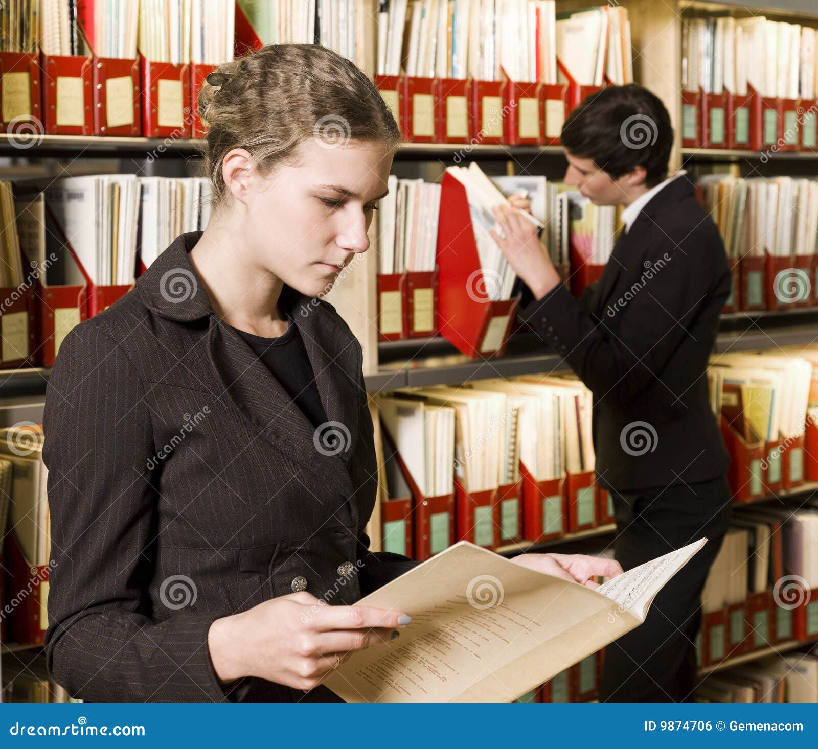 Two women at a library stock photo. Image of reaching - 9874706