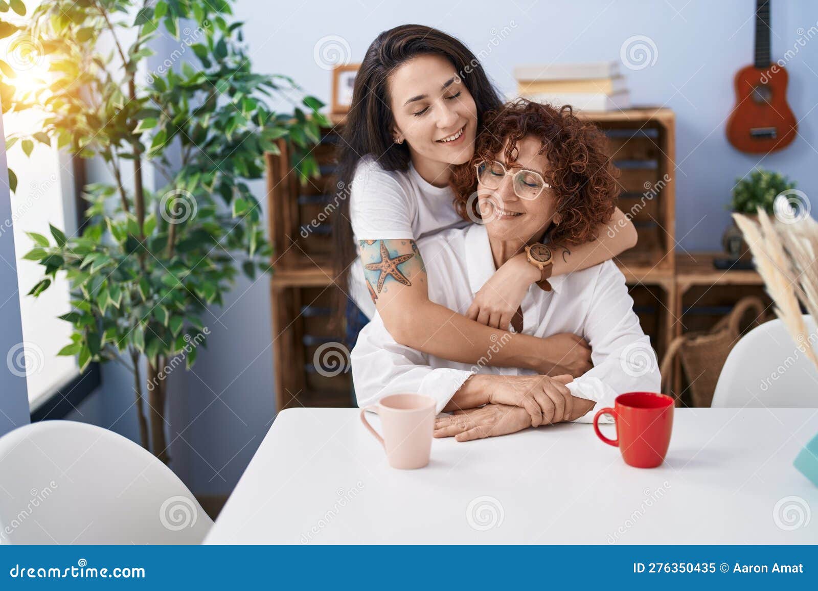 Two Women Mother And Daughter Drinking Coffee Hugging Each Other At