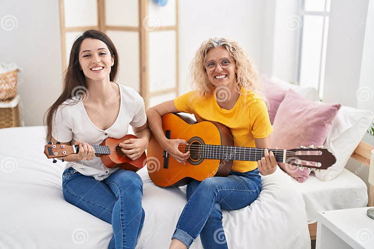 Two Women Mother And Daughter Playing Classical Guitar And Ukulele At