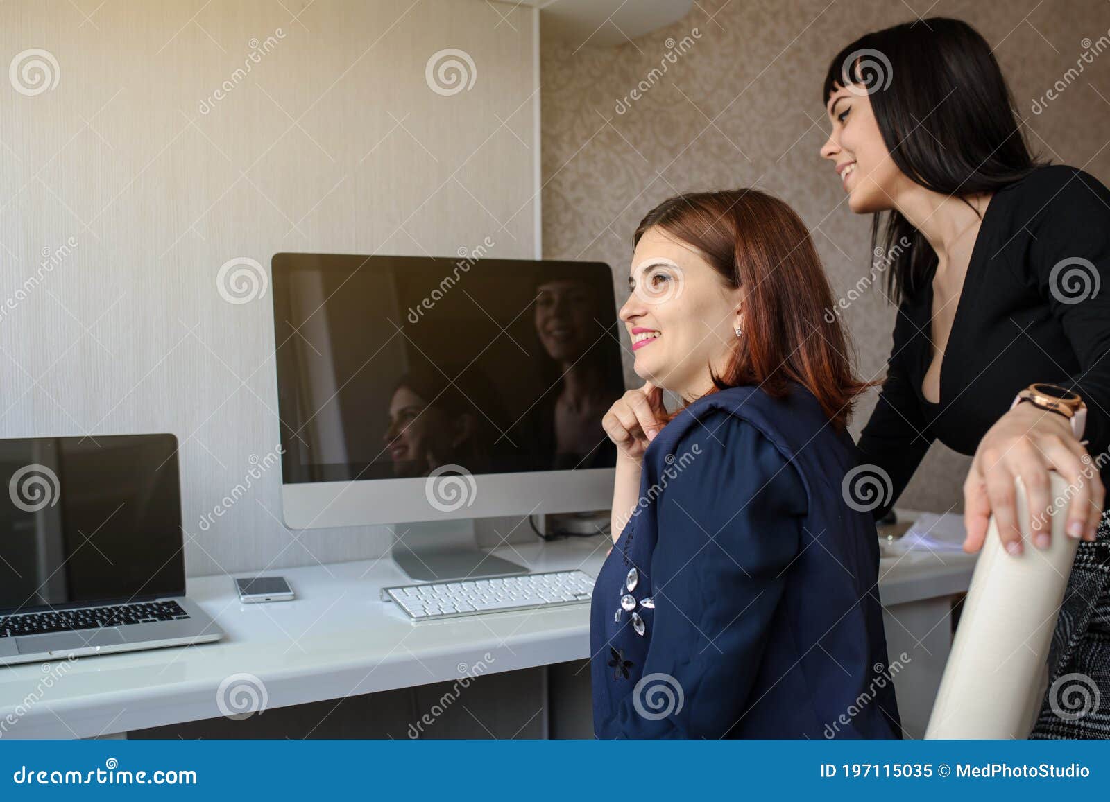 Two Women in Office Outfit Working on Computers and Discussing a Report ...