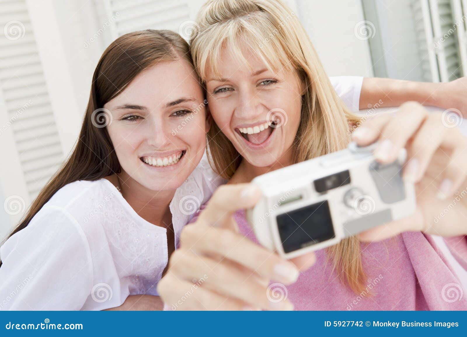 Two Women on Patio Using Digital Camera Stock Photo - Image of back ...