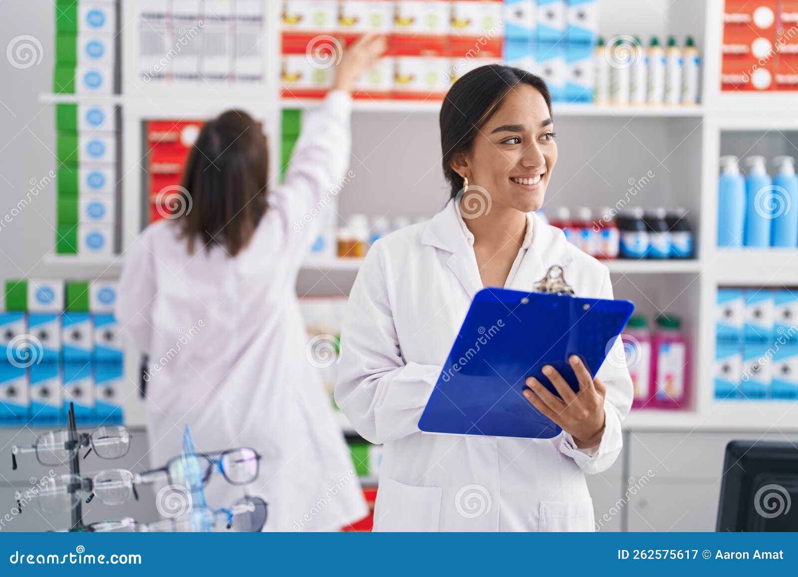 Two Women Pharmacist Smiling Confident Writing on Document at Pharmacy ...