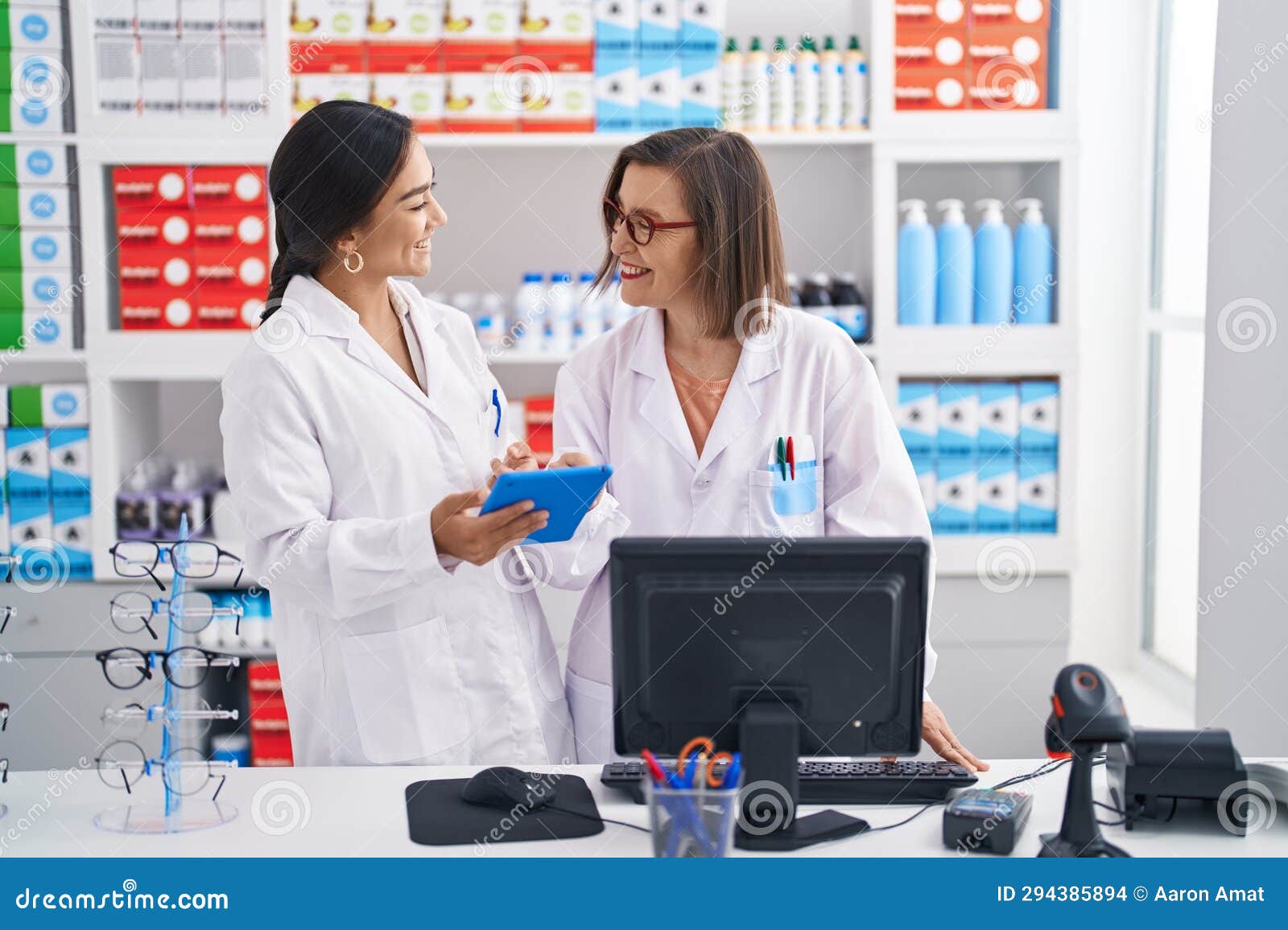 Two Women Pharmacist Using Computer and Touchpad Working at Pharmacy ...
