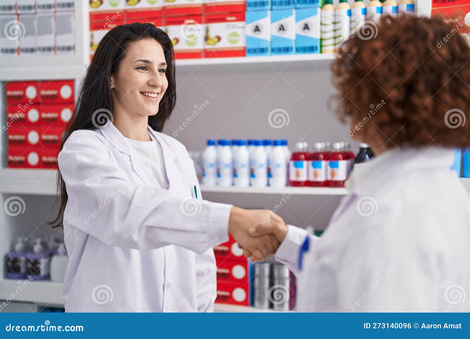 Two Women Pharmacists Smiling Confident Shake Hands at Pharmacy Stock ...