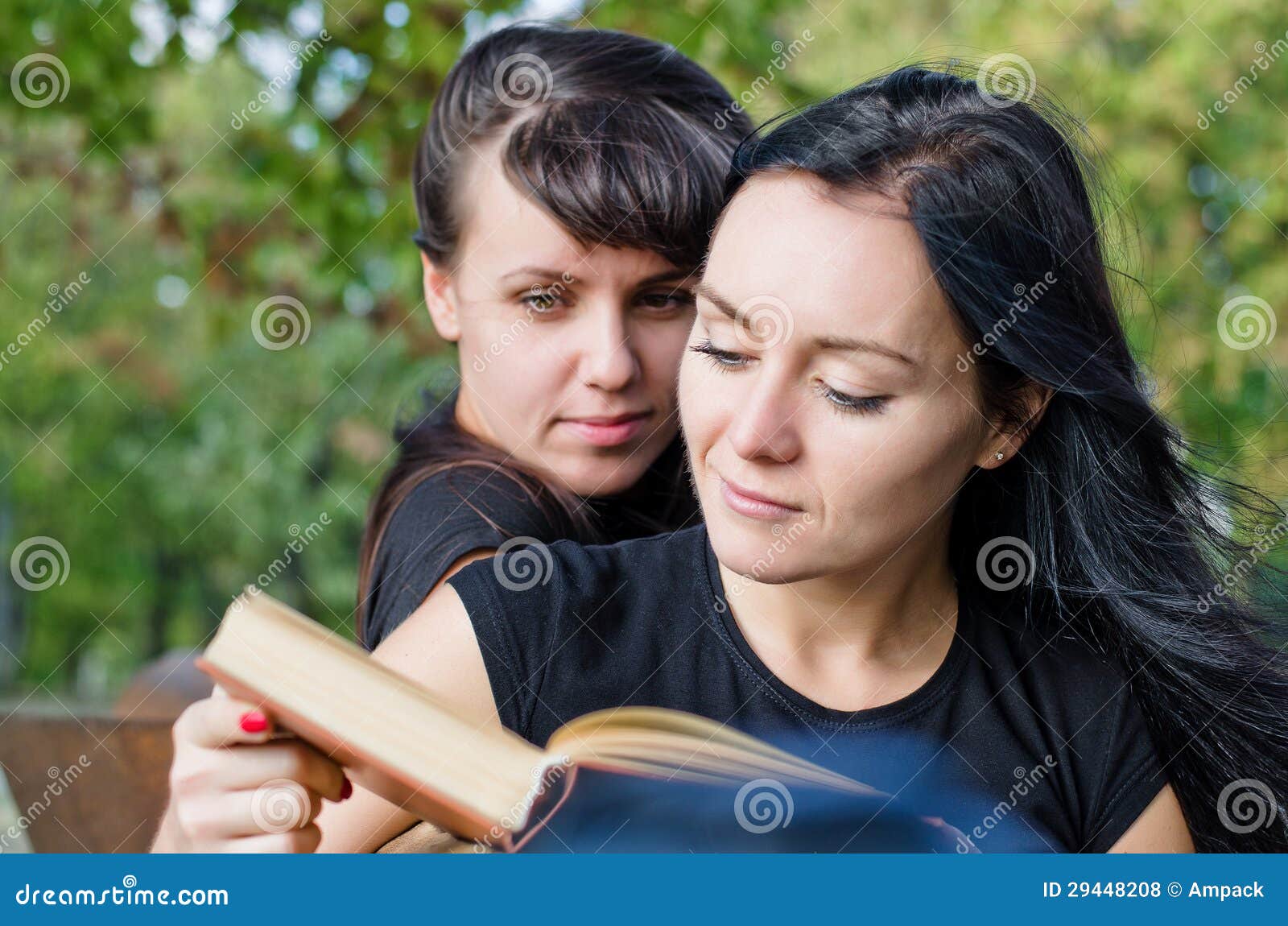 Two Women Reading a Book Together Stock Photo - Image of closeness ...
