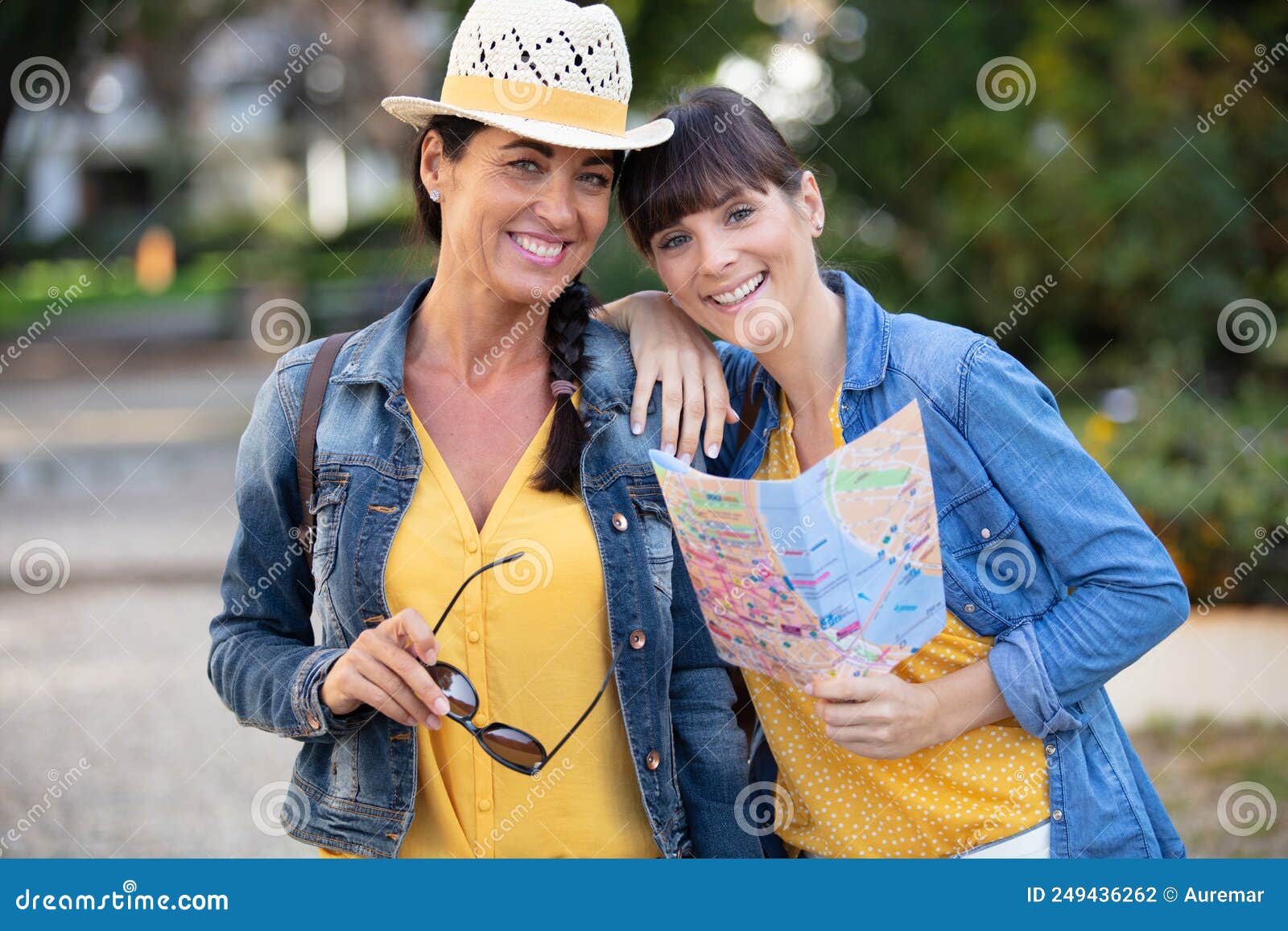 Two women reading map stock photo. Image of standing - 249436262