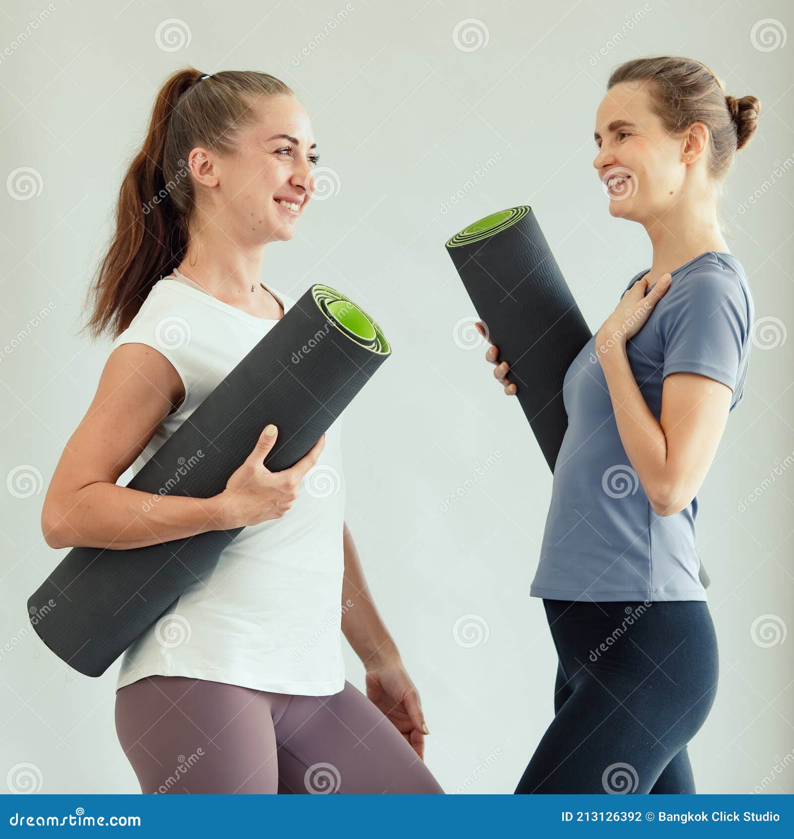 Two Women Rolling Yoga Mats after Class with Happiness Stock Photo ...