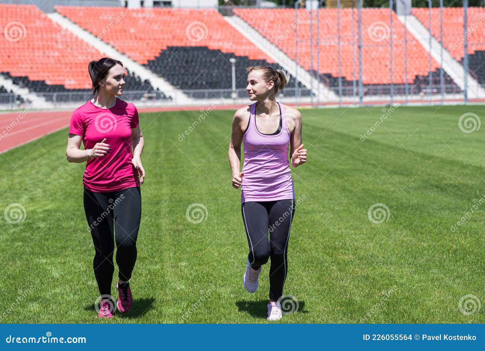 Two Women Running in the Stadium on the Grass. Stock Photo - Image of ...