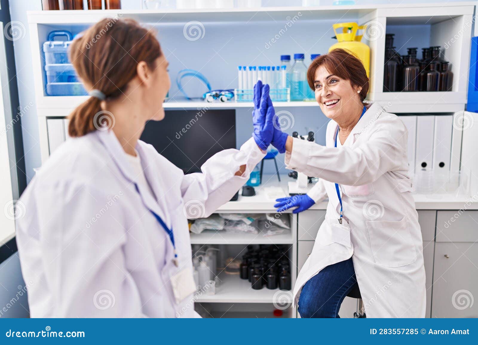 Two Women Scientist Smiling Confident High Five with Hands Raised Up at ...
