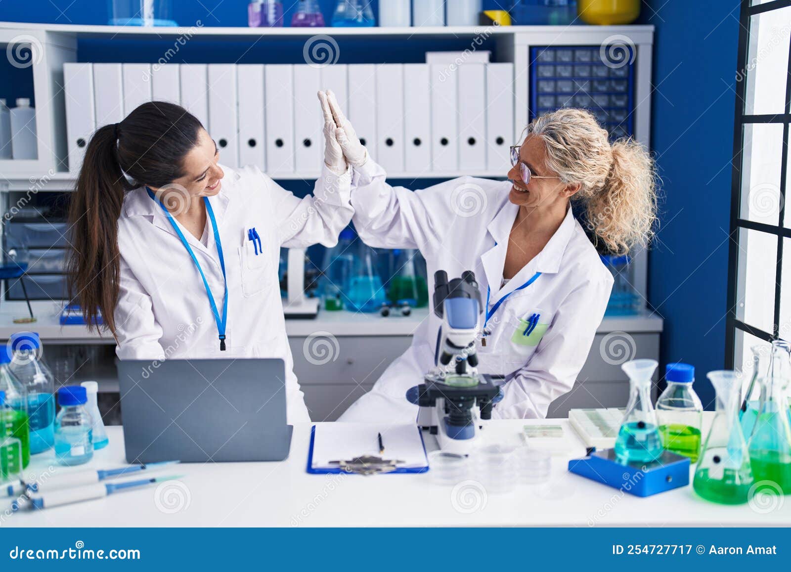 Two Women Scientists High Five with Hands Raised Up Working at ...