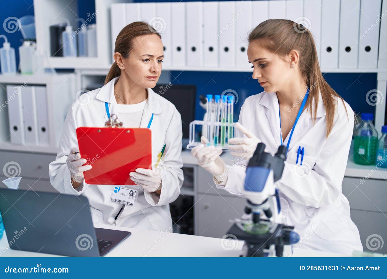 Two Women Scientists Write on Document Holding Test Tubes at Laboratory ...