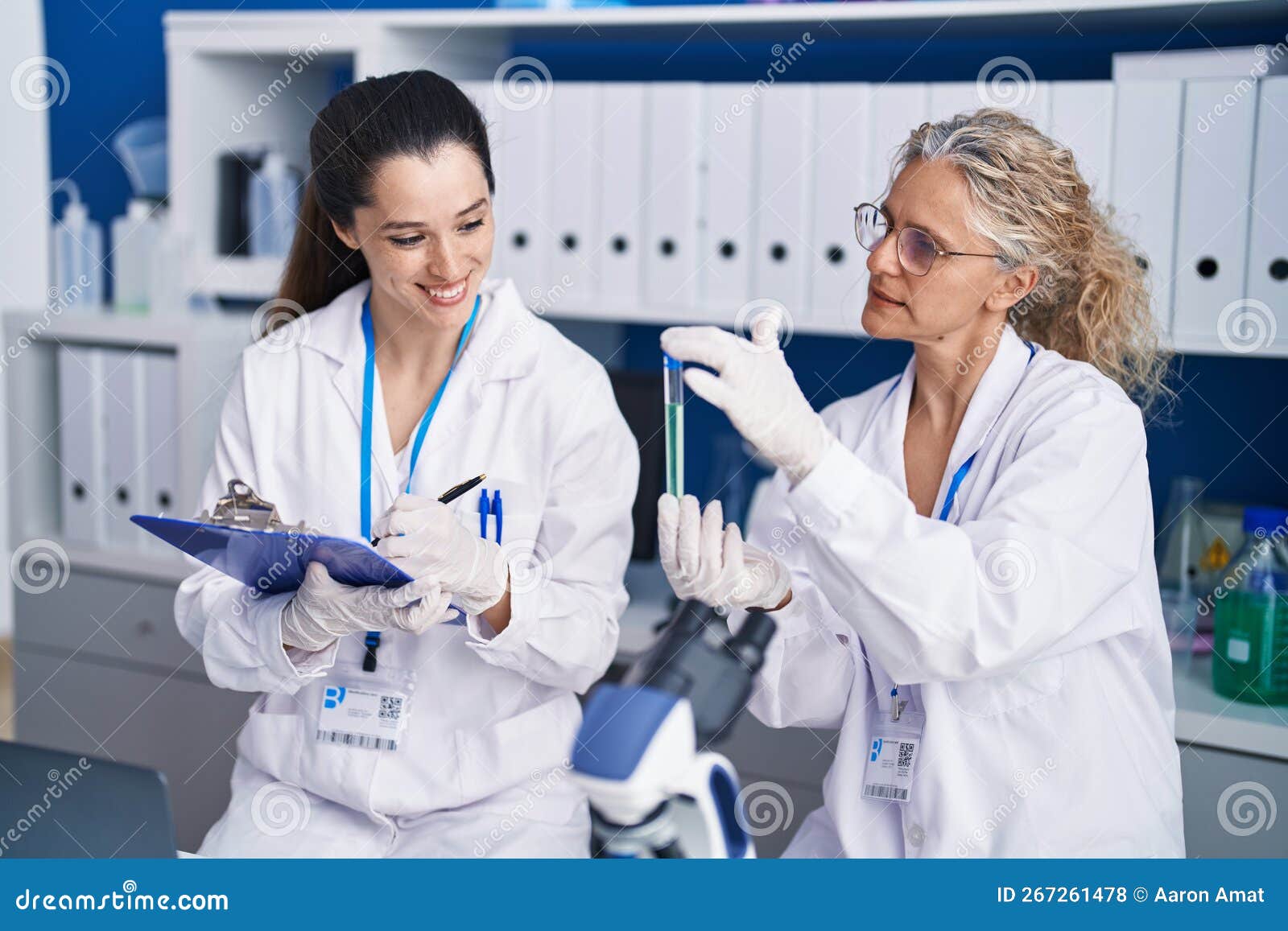 Two Women Scientists Write on Document Measuring Liquid at Laboratory ...