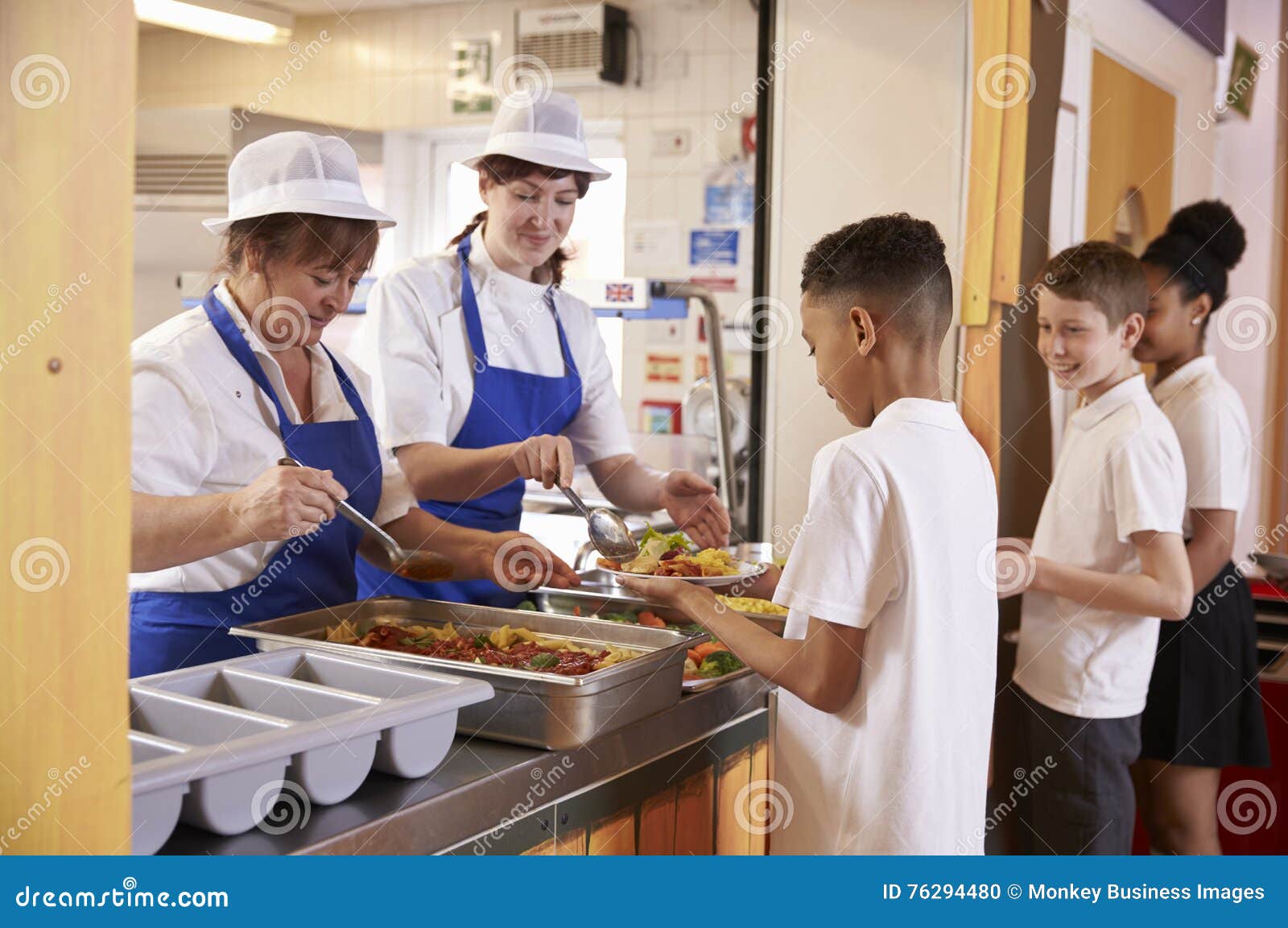 Two Women Serving Food To a Boy in a School Cafeteria Queue Stock Photo ...