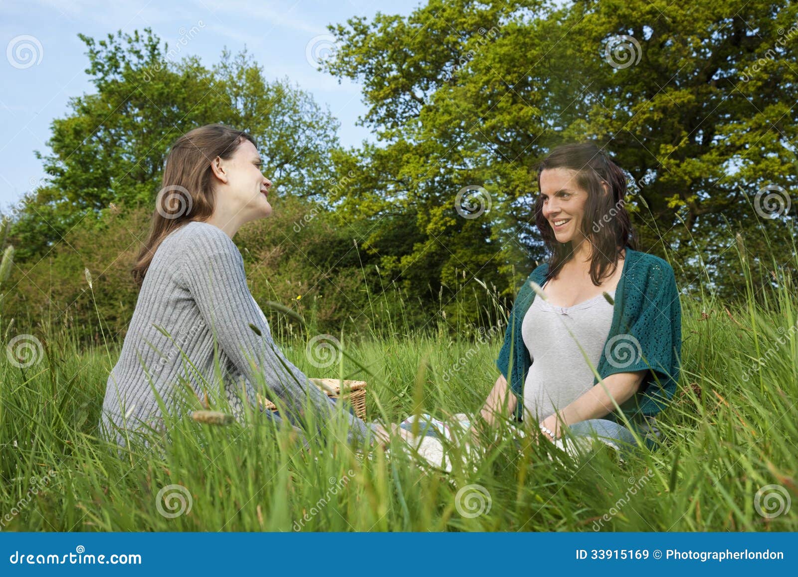 Two Women Sitting on Grass stock image. Image of basket - 33915169