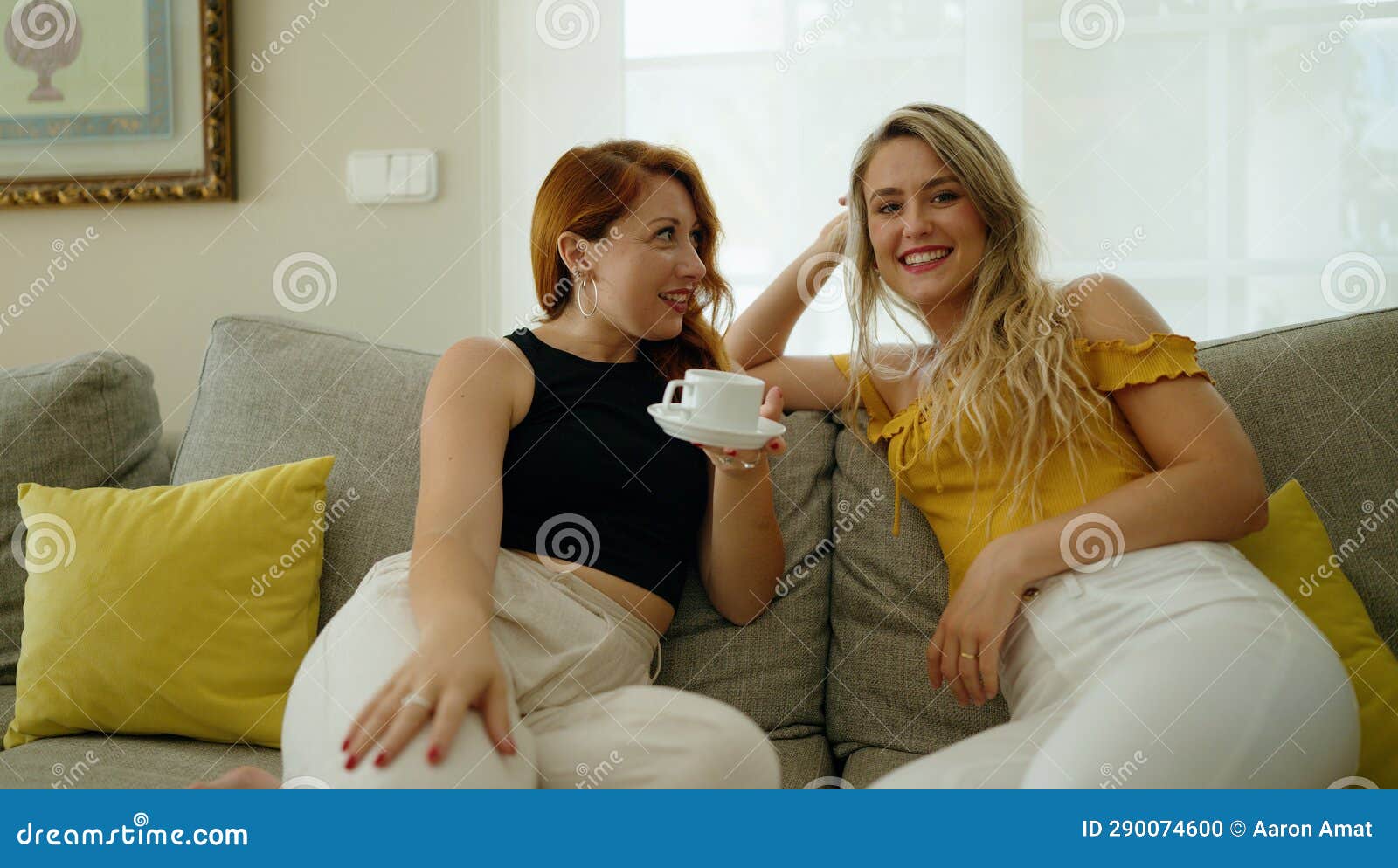 Two Women Sitting on Sofa Speaking and Drinking Coffee at Home Stock ...