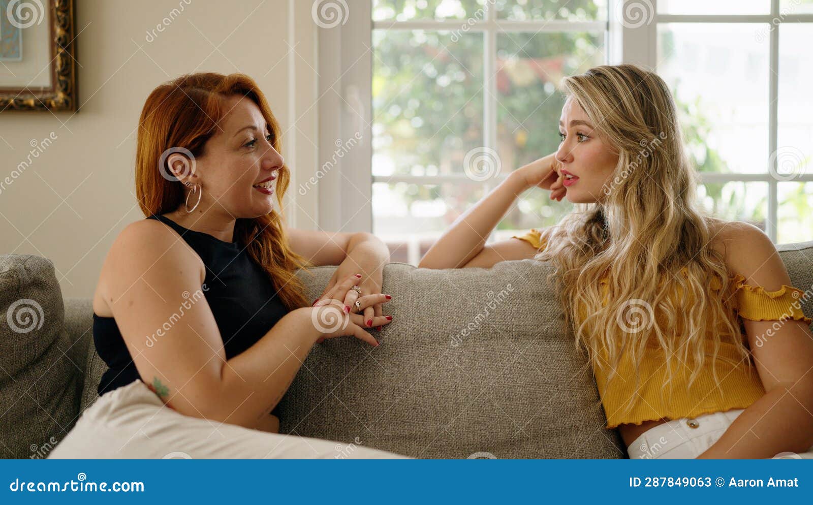 Two Women Sitting On Sofa Speaking At Home Stock Image Image Of