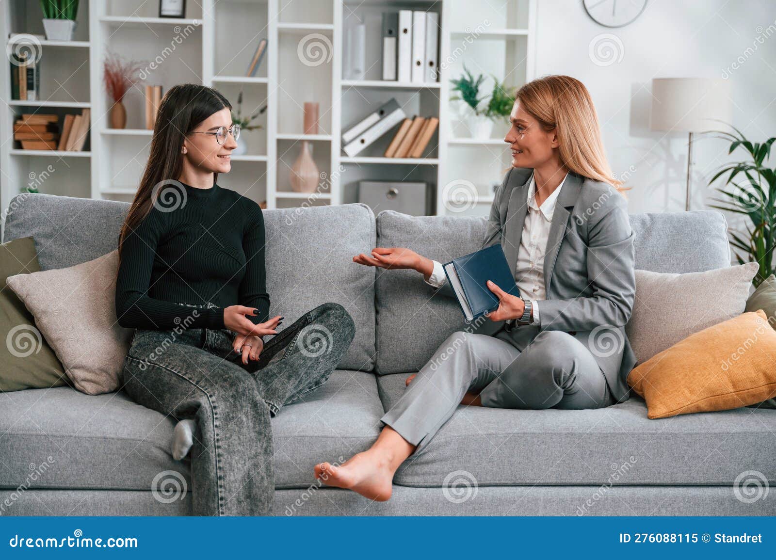 Two Women is Sitting on the Sofa and Talking. Casual and Formal Clothes ...