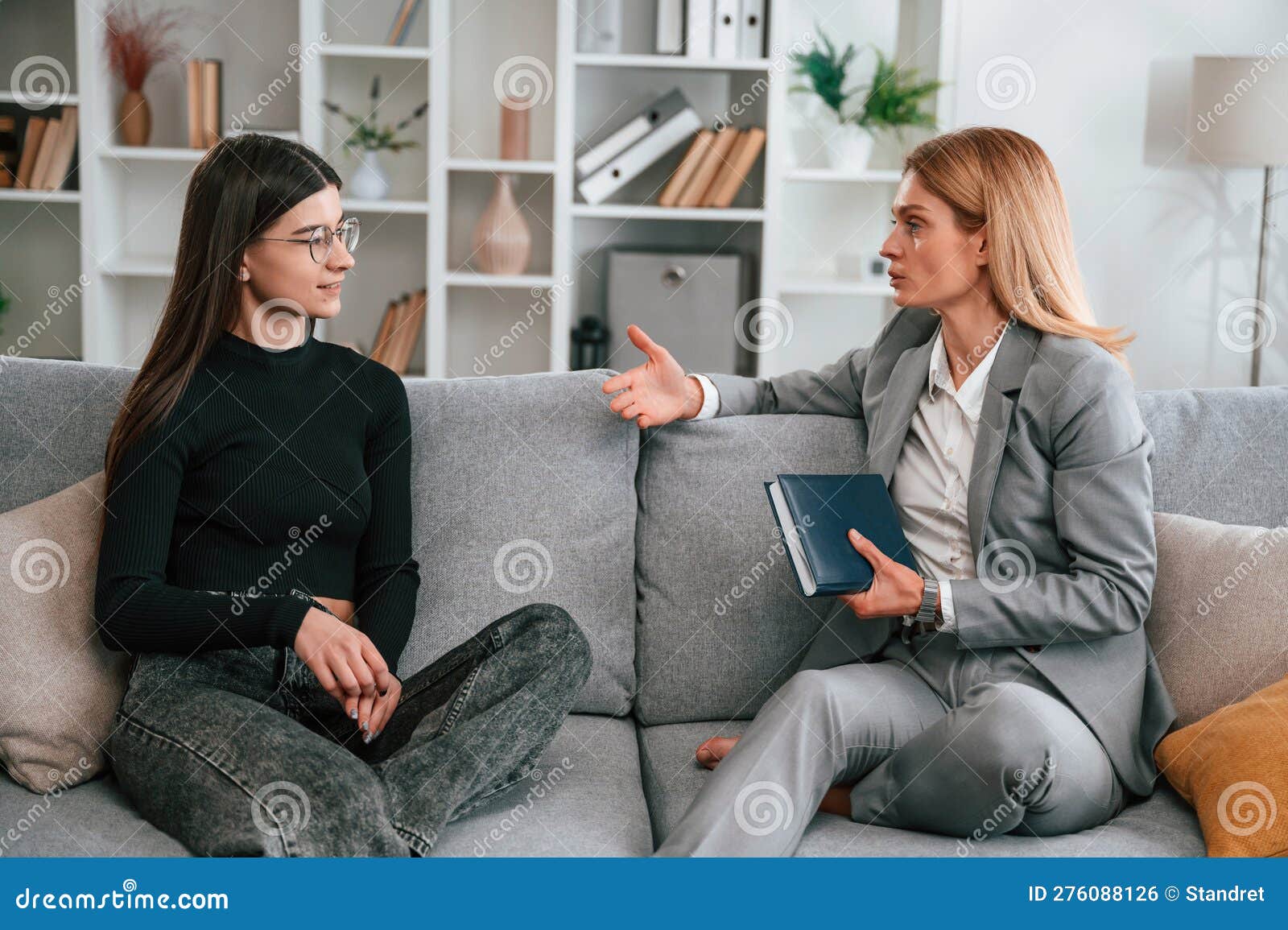 Two Women is Sitting on the Sofa and Talking. Casual and Formal Clothes ...