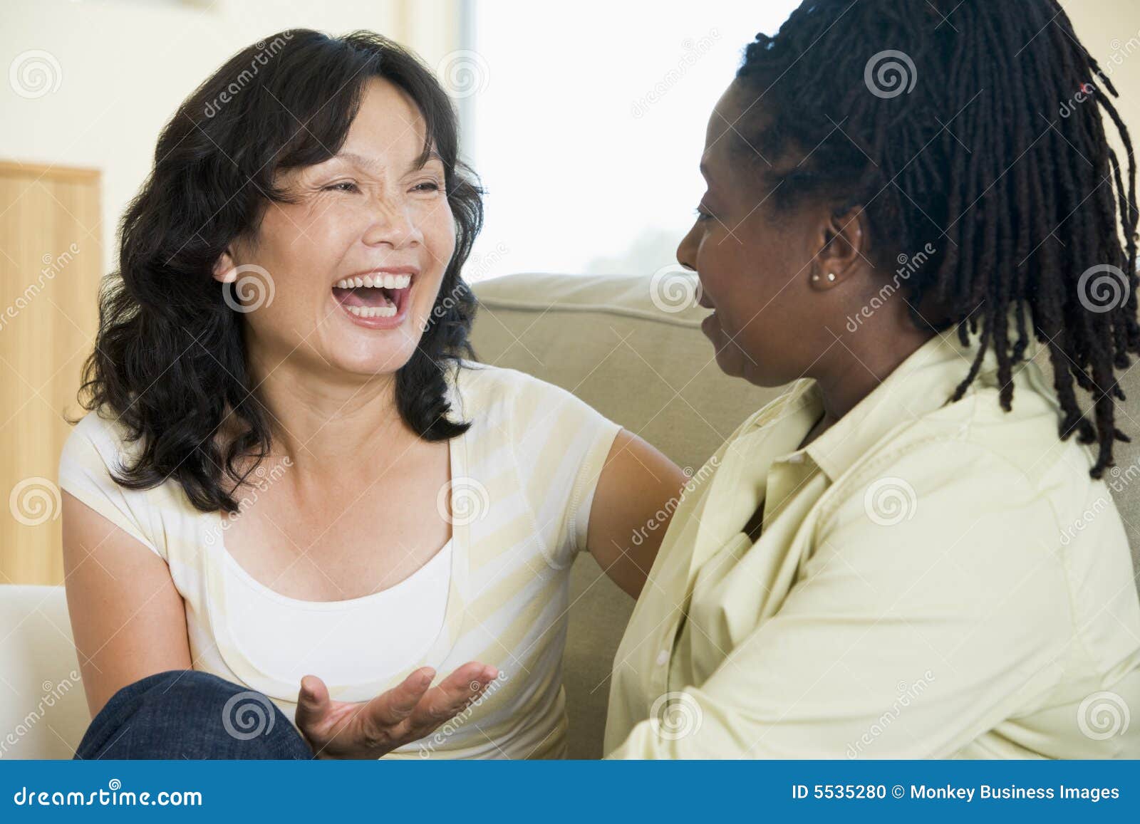 Two Women Talking in Living Room and Smiling Stock Photo - Image of ...