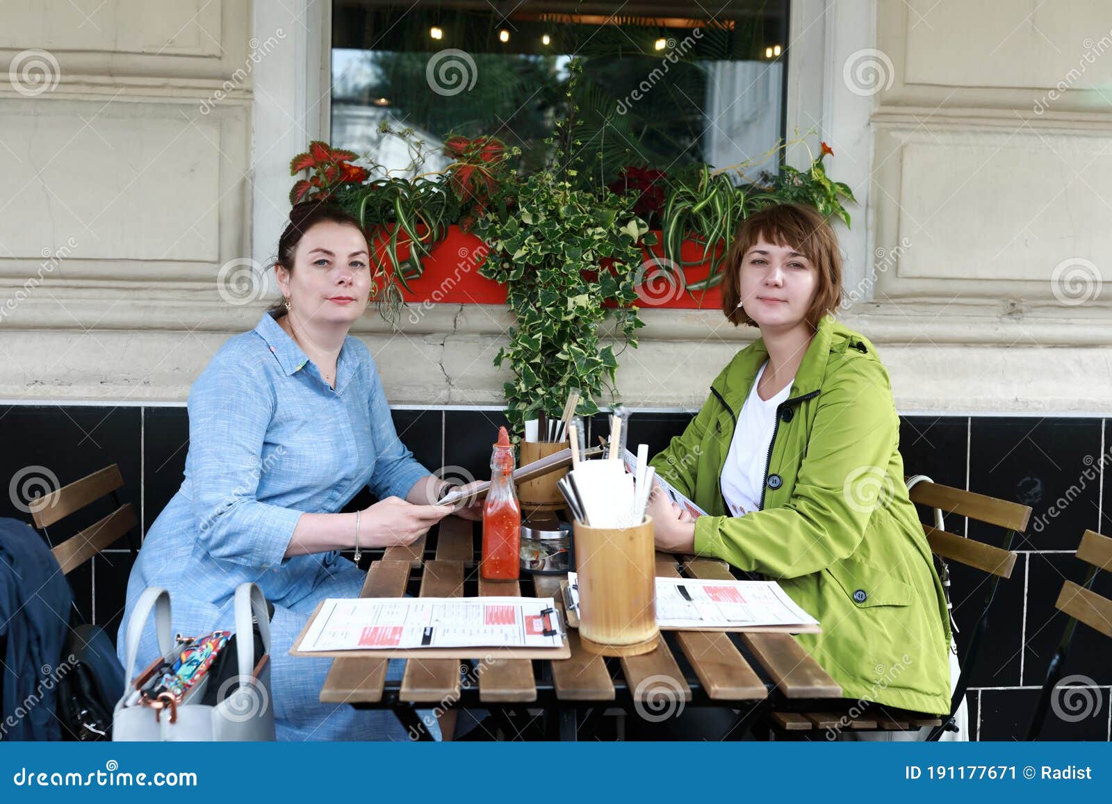 Two Women on Veranda of Restaurant Stock Image - Image of menu, adult ...