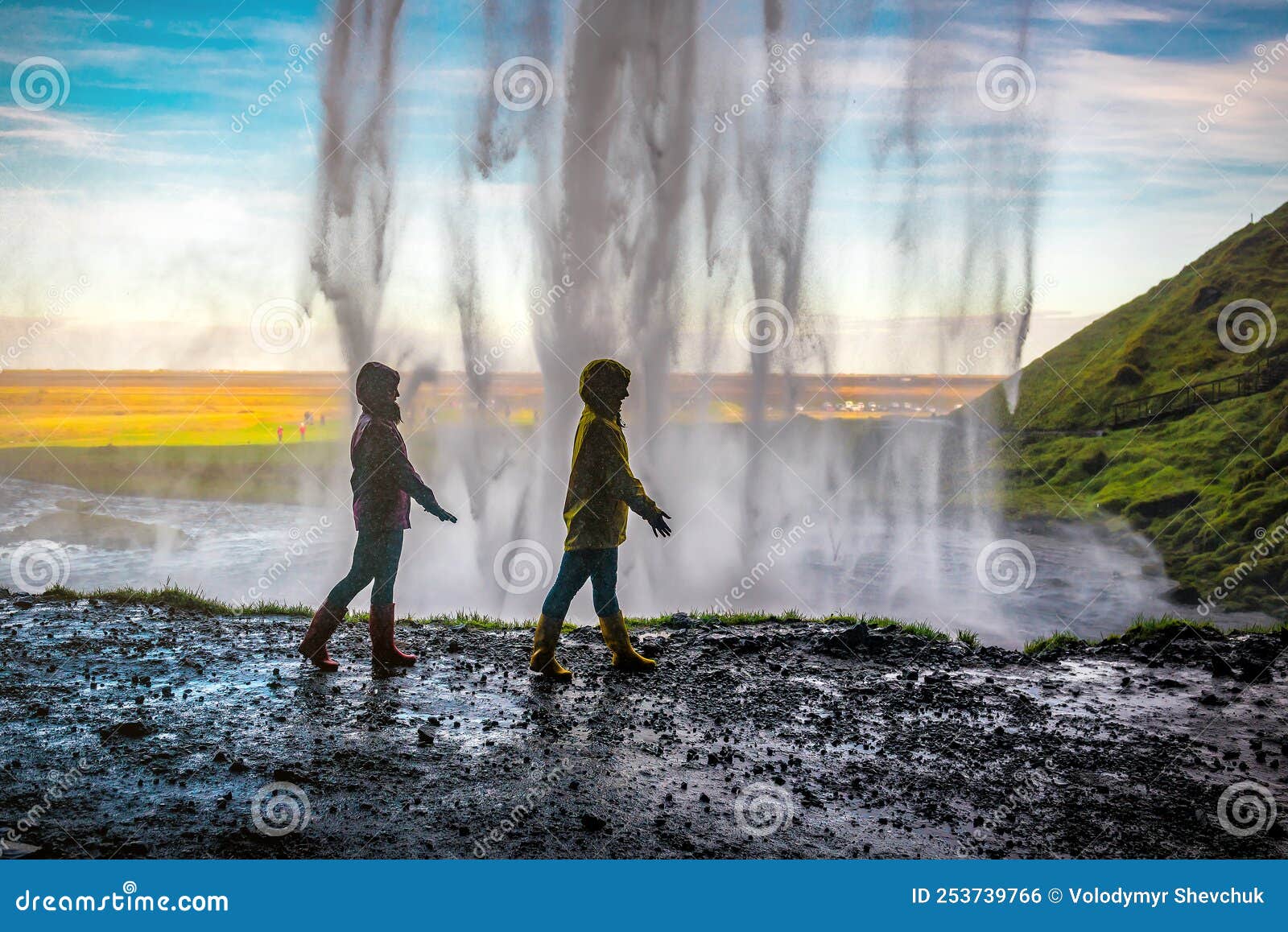 Two Women Walking Under a Waterfall Seljalandsfoss in Iceland Stock ...