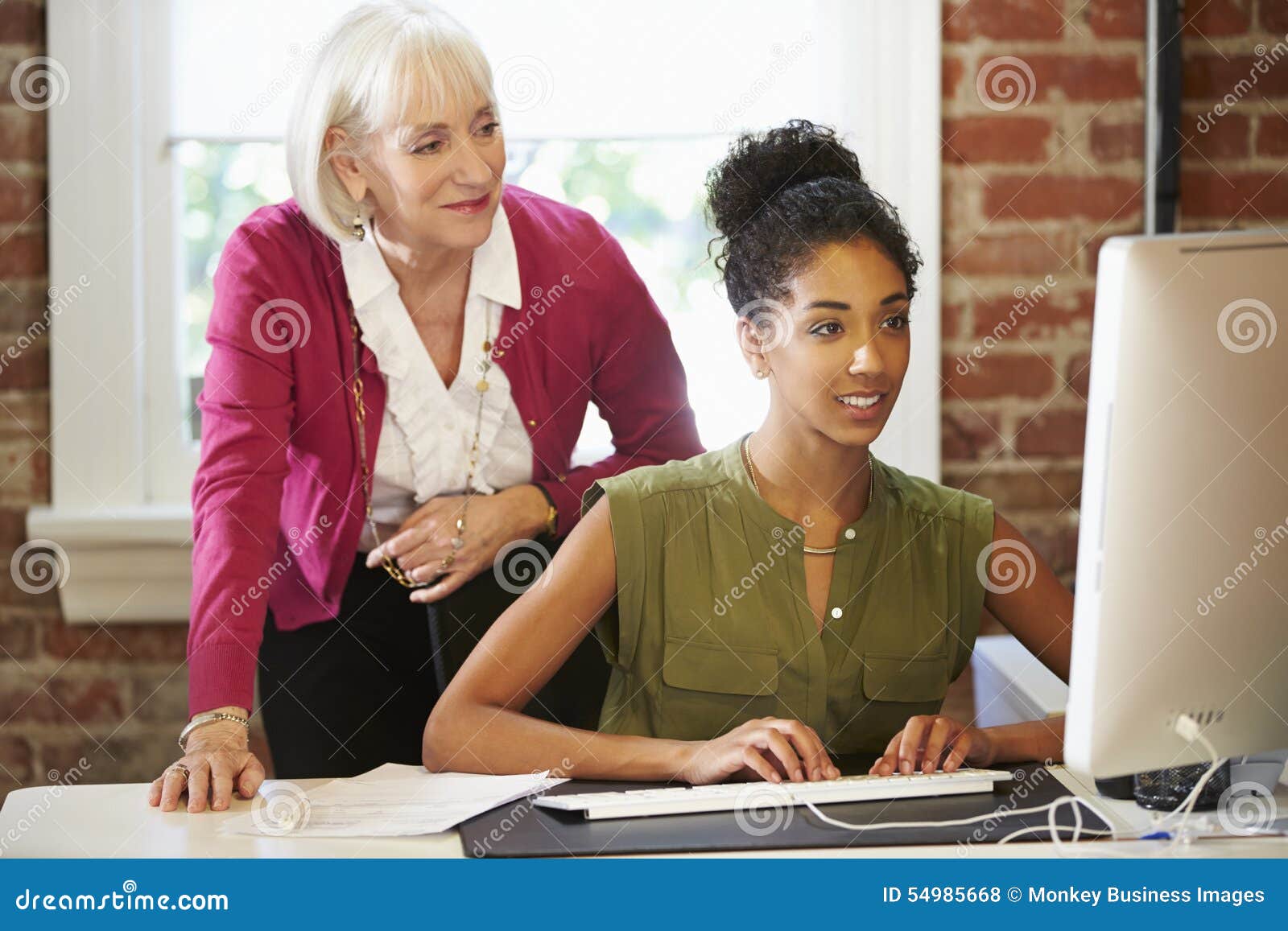 Two Women Working at Computer in Contemporary Office Stock Photo ...