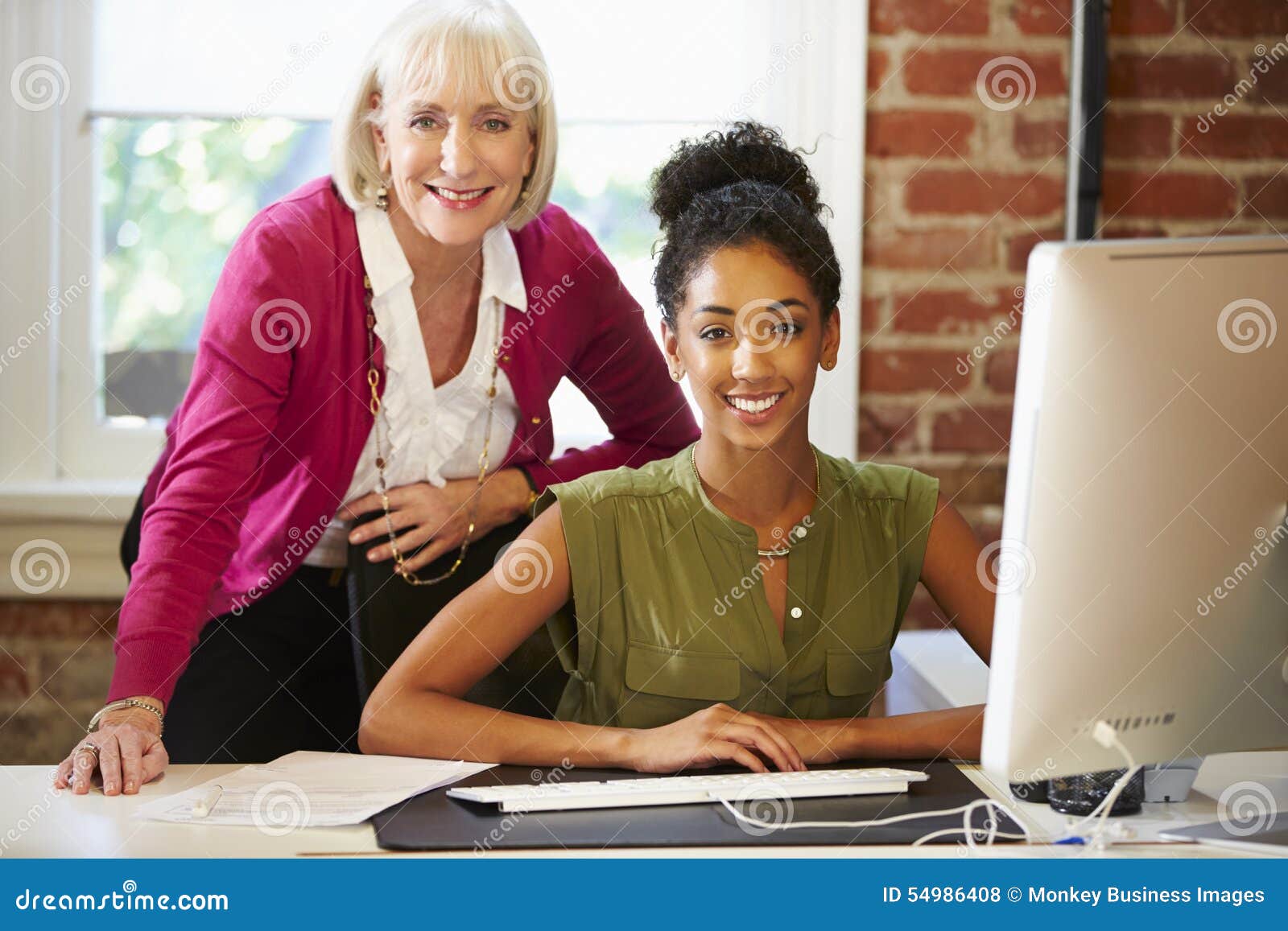 Two Women Working at Computer in Contemporary Office Stock Photo ...