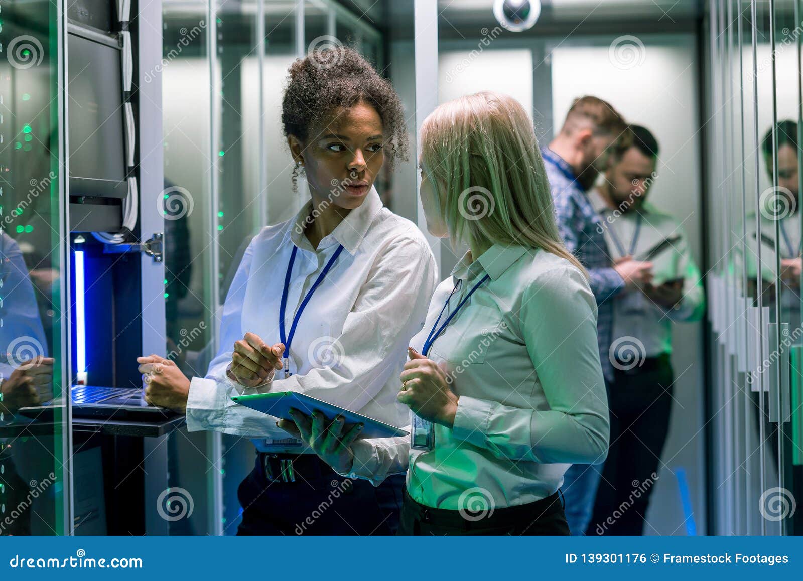 Two Women are Working in a Data Center with Rows of Server Racks Stock ...