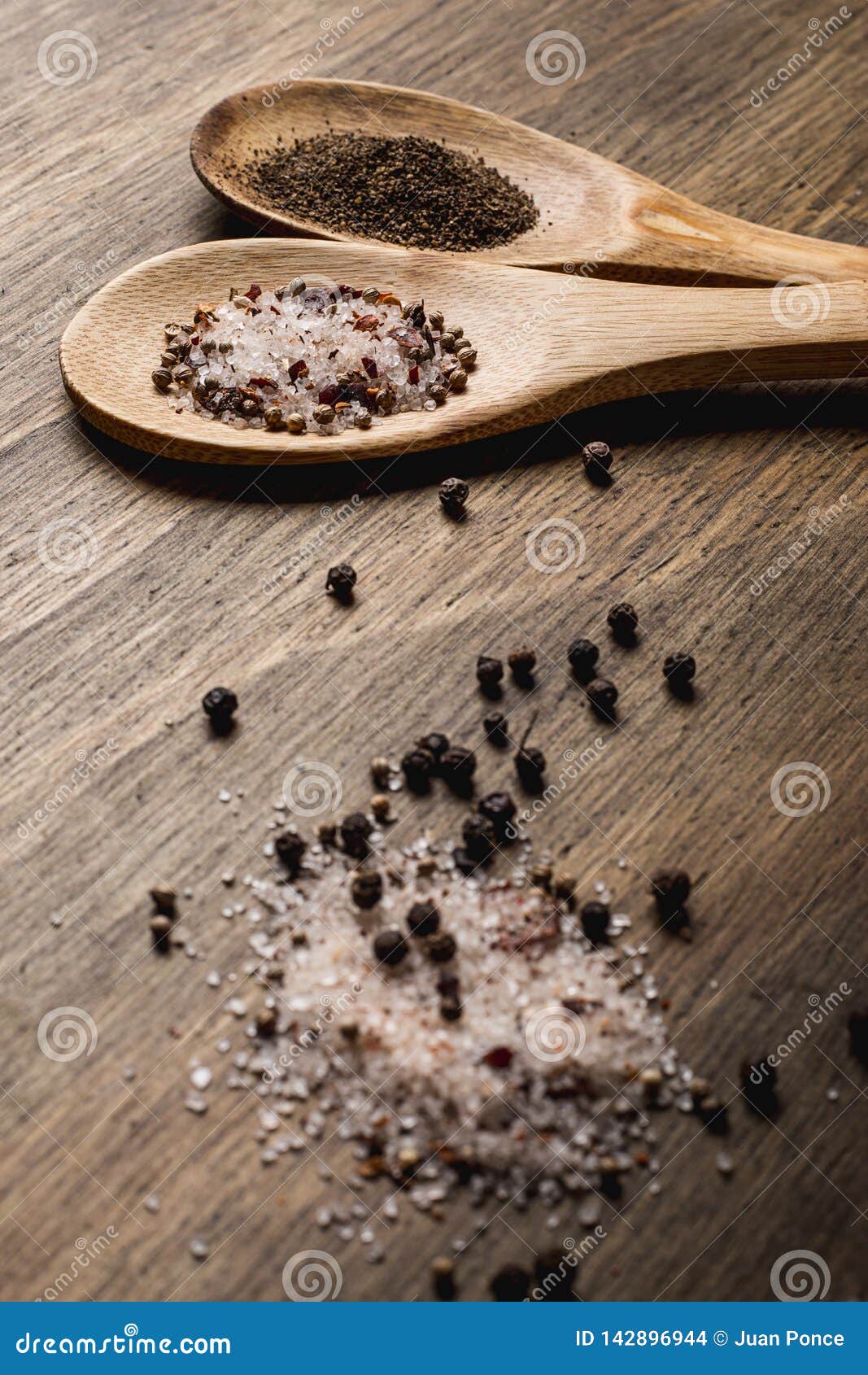 Two Wooden Spoons with Salt and Pepper on a Wooden Table Stock Photo ...