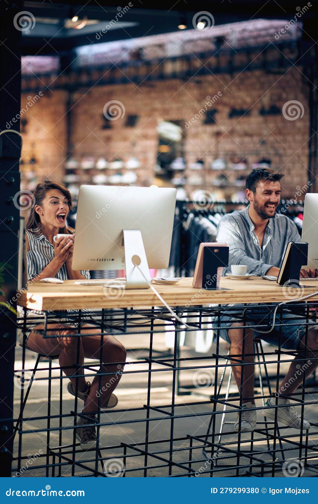 Two Workers in a Clothing Store Working at the Desk, Sitting in Front ...