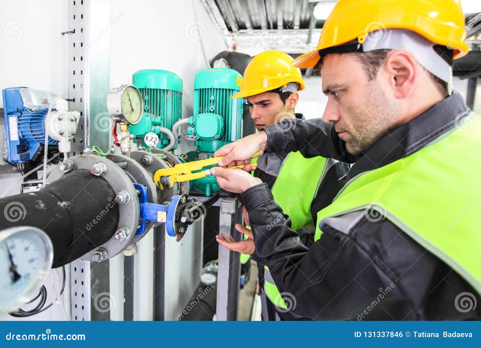 Two workers fixing pipes stock photo. Image of builder - 131337846