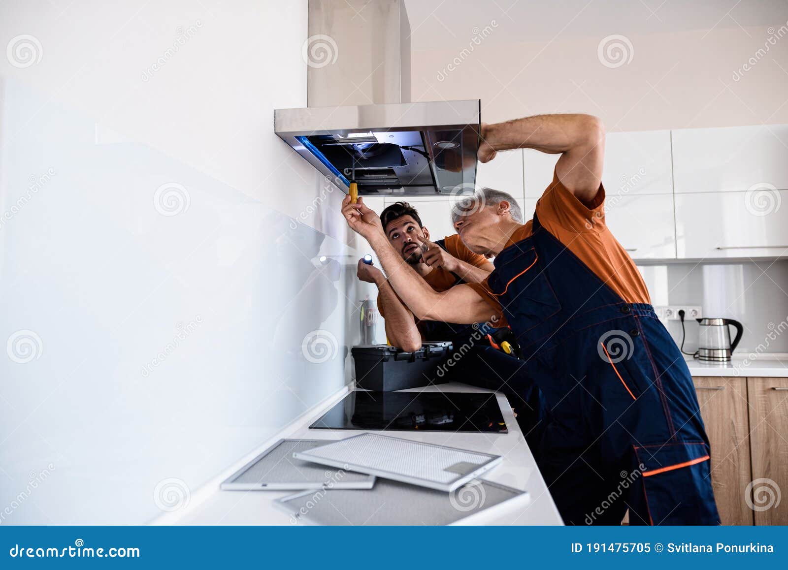Two Workers, Handyman In Uniform Installing Or Repairing A Kitchen ...