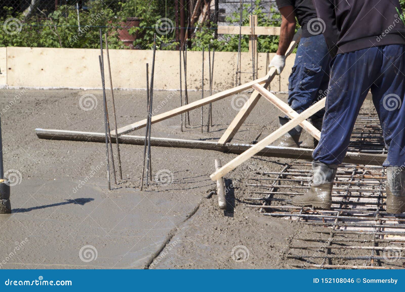 Two Workers Leveling Fresh Concrete Slab with a Special Working Stock ...
