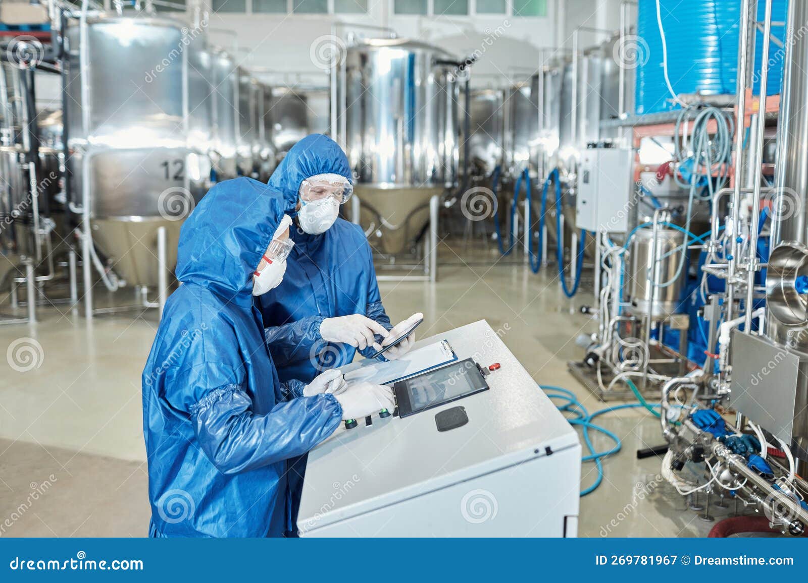 Two Workers Operating Equipment at Factory and Using Control Panel ...