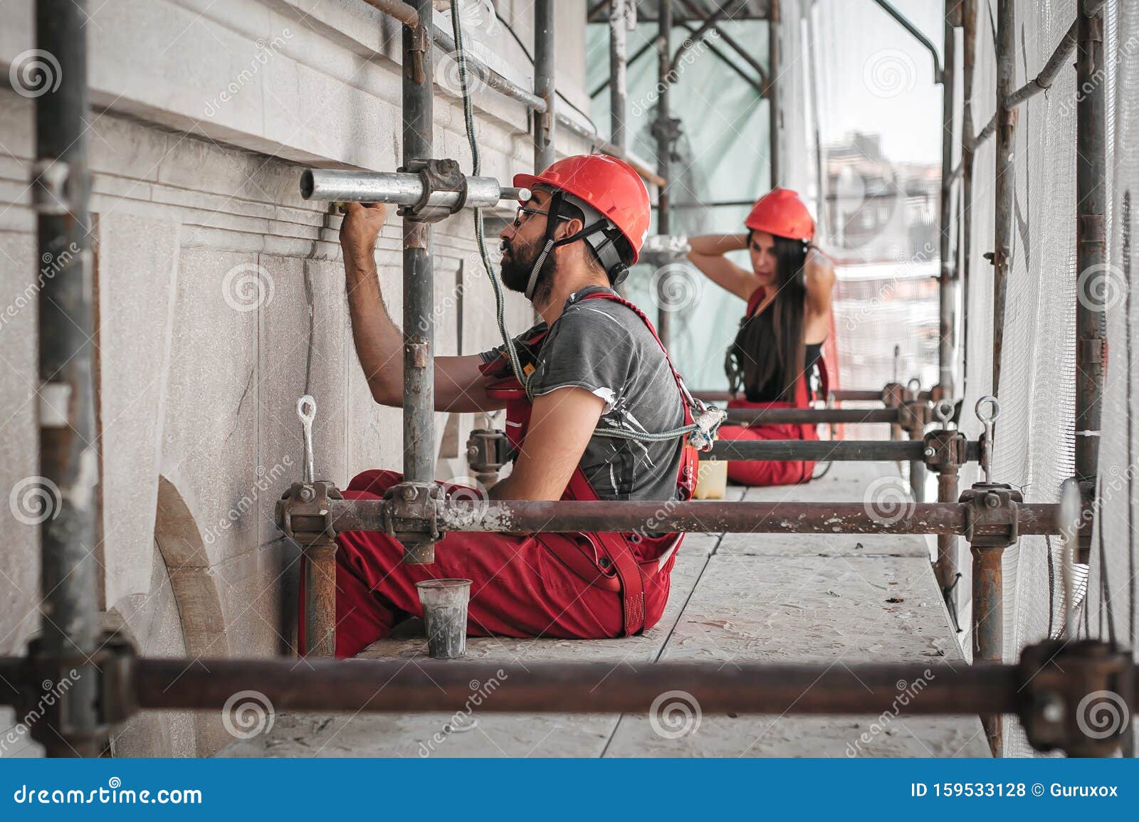 Two Workers on the Scaffolding, Plastering and Renovating Old Building ...