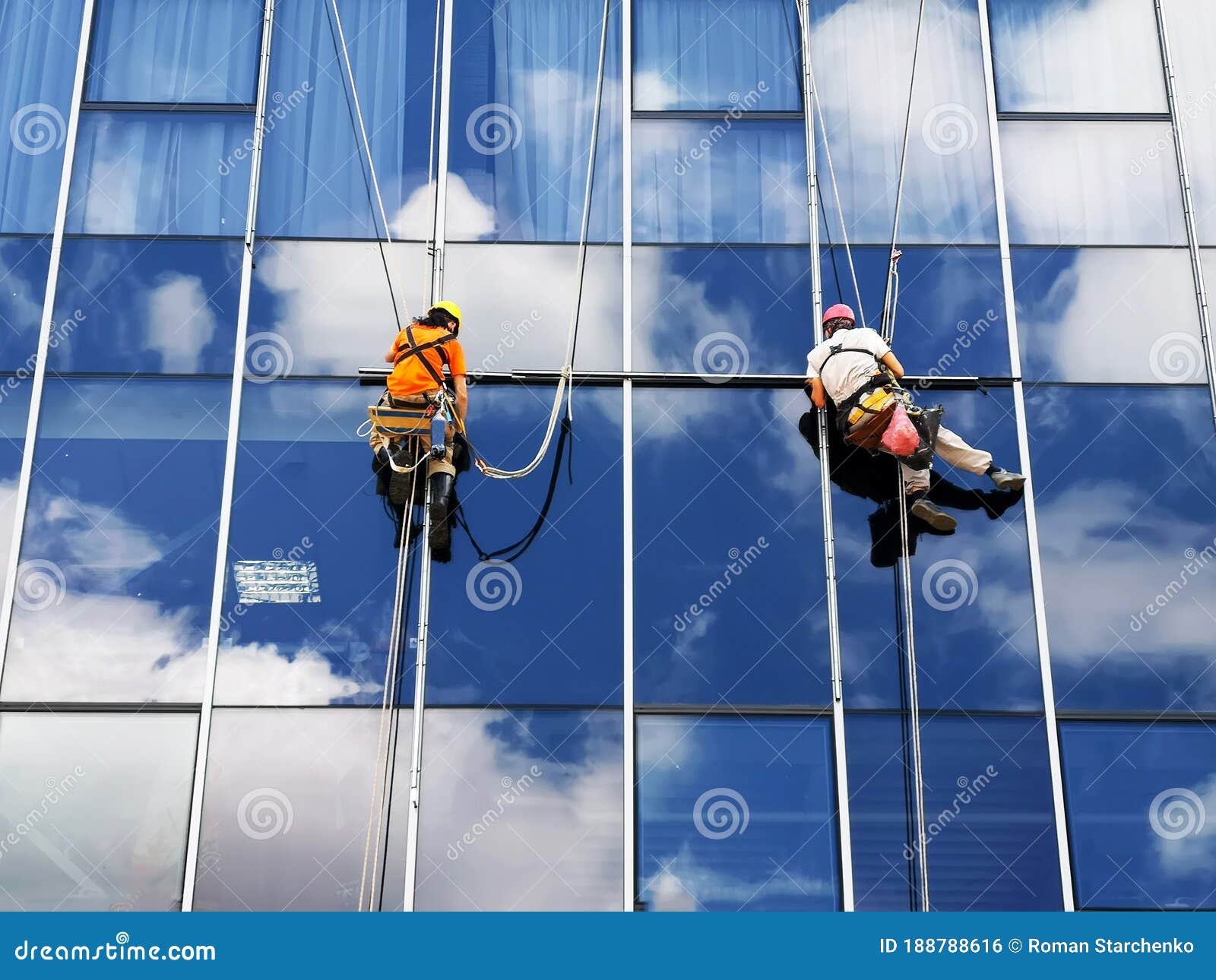 Two Working Climbers are on a Glass Wall of a High-rise Building ...