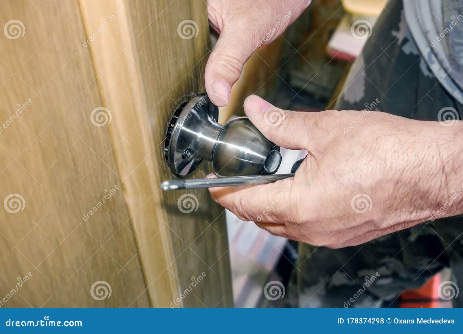 Two Working Hands of a Carpenter when Installing a Lock in a Wooden ...
