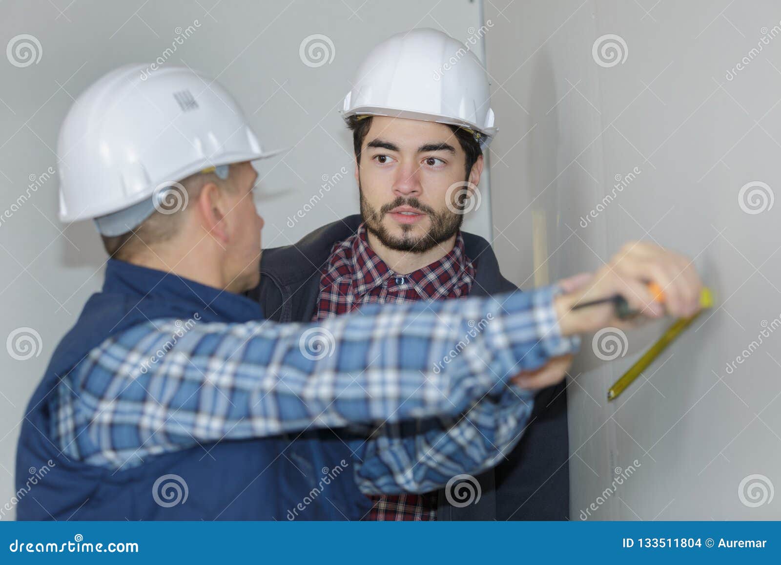 Two Workmen Measuring Interior Wall with Tae Measure Stock Photo ...