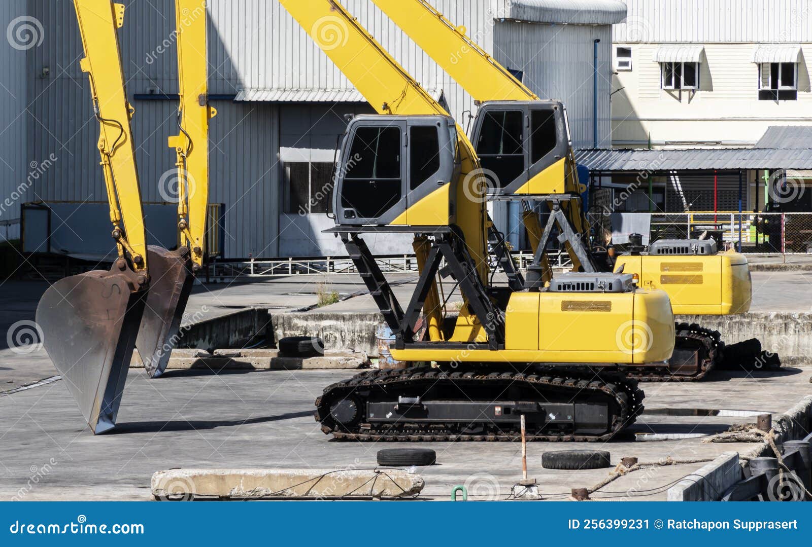 Two yellow backhoe on dock stock image. Image of harbour - 256399231